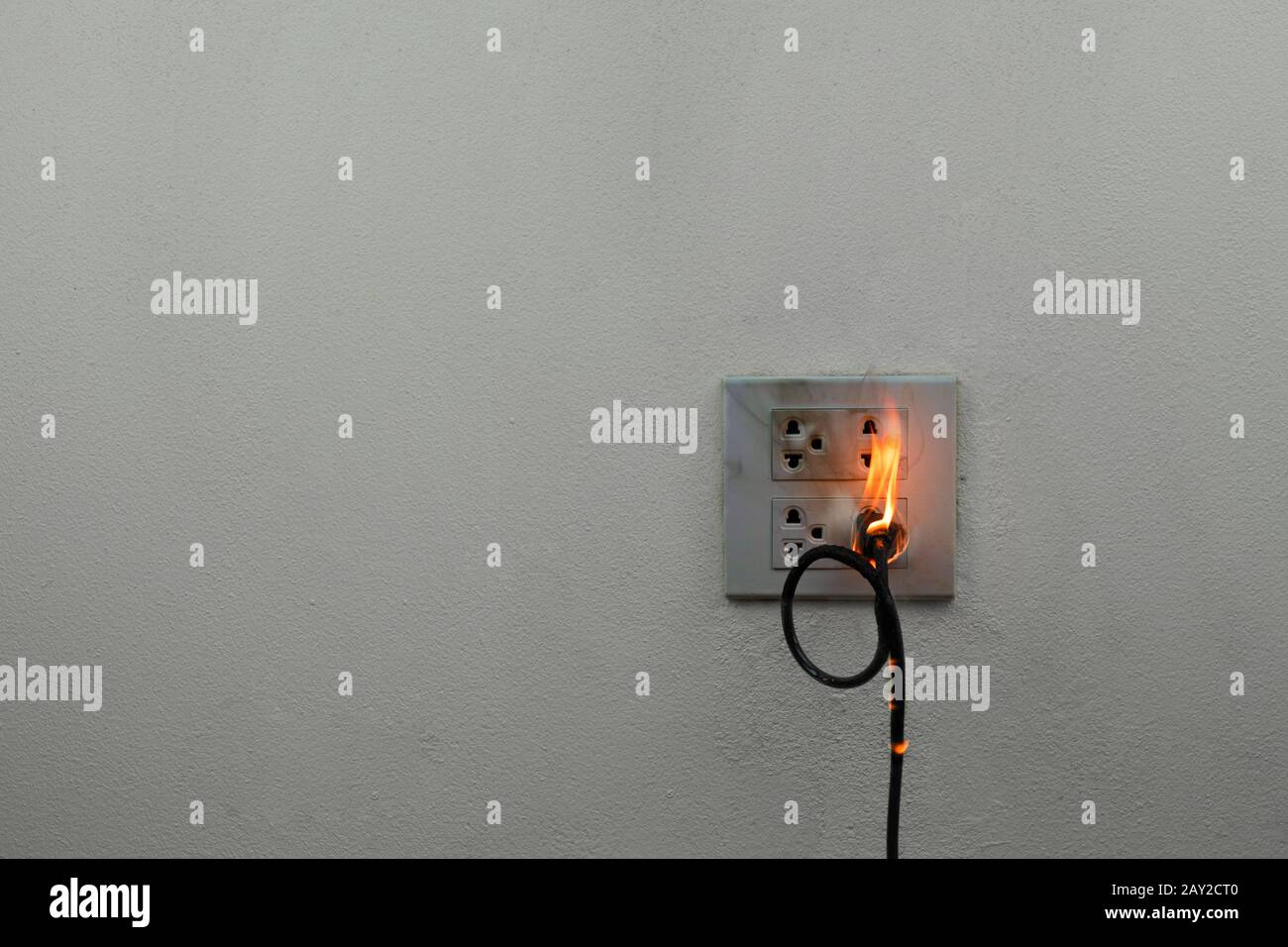 On fire electric wire plug in the receptacle at wall partition ...