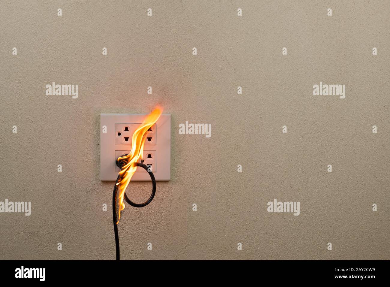 On fire electric wire plug in the receptacle at wall partition ...