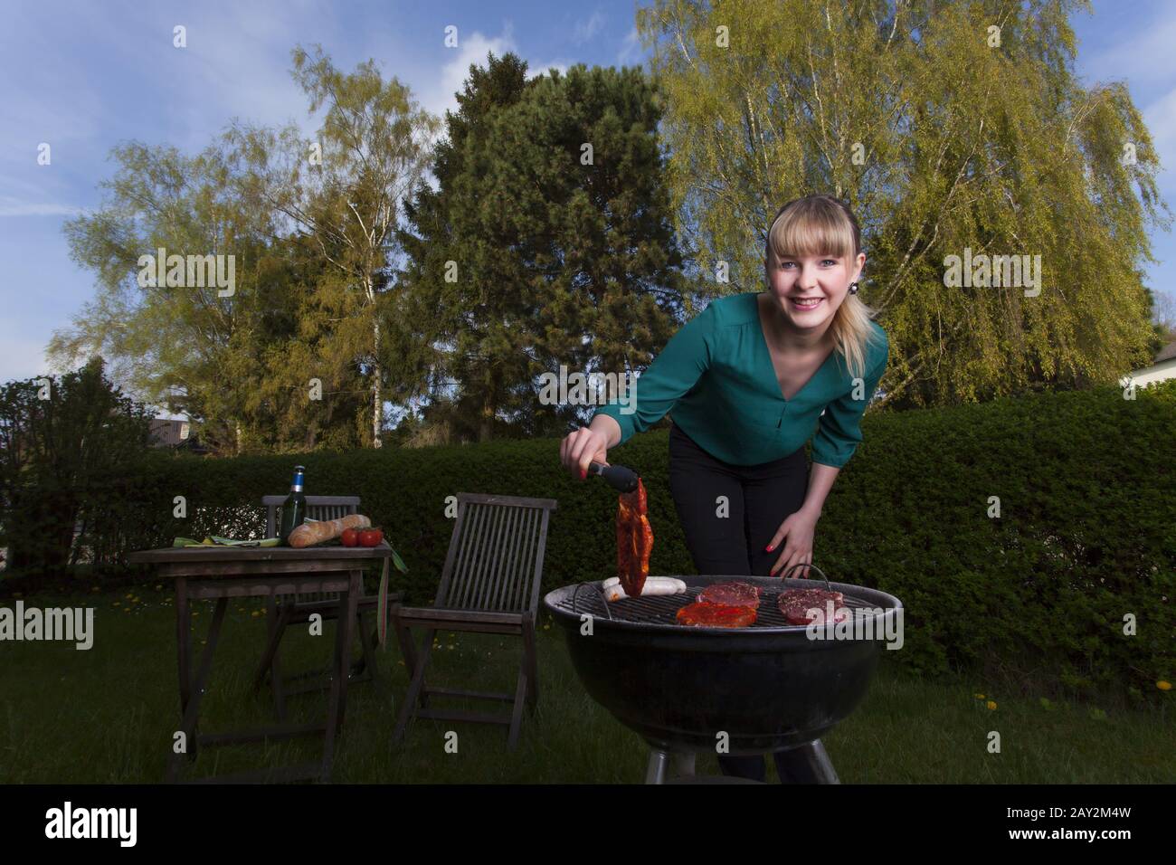 Woman barbecuing meat hi-res stock photography and images - Alamy