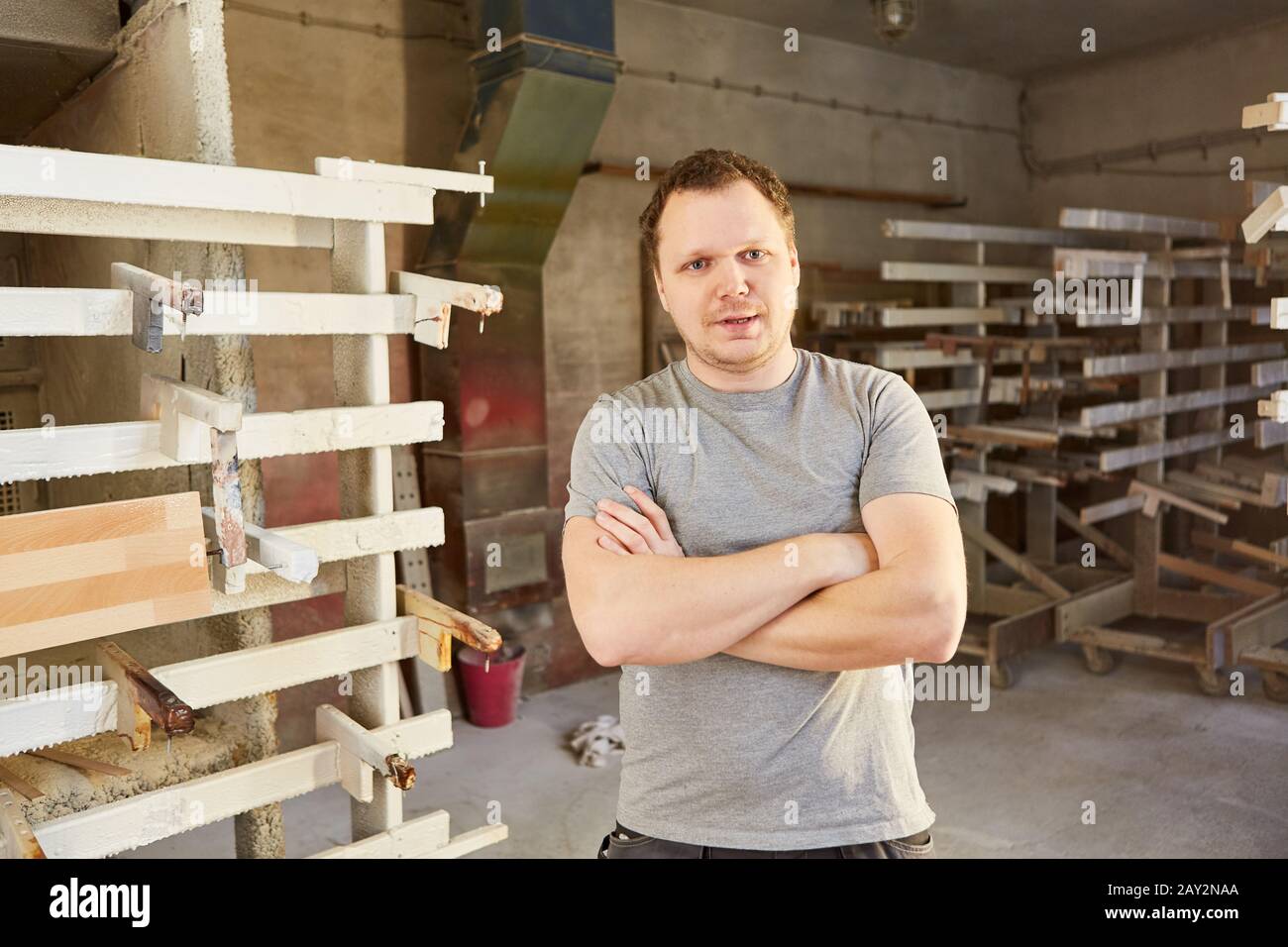 Young man as carpenter apprentice with crossed arms in carpentry Stock ...