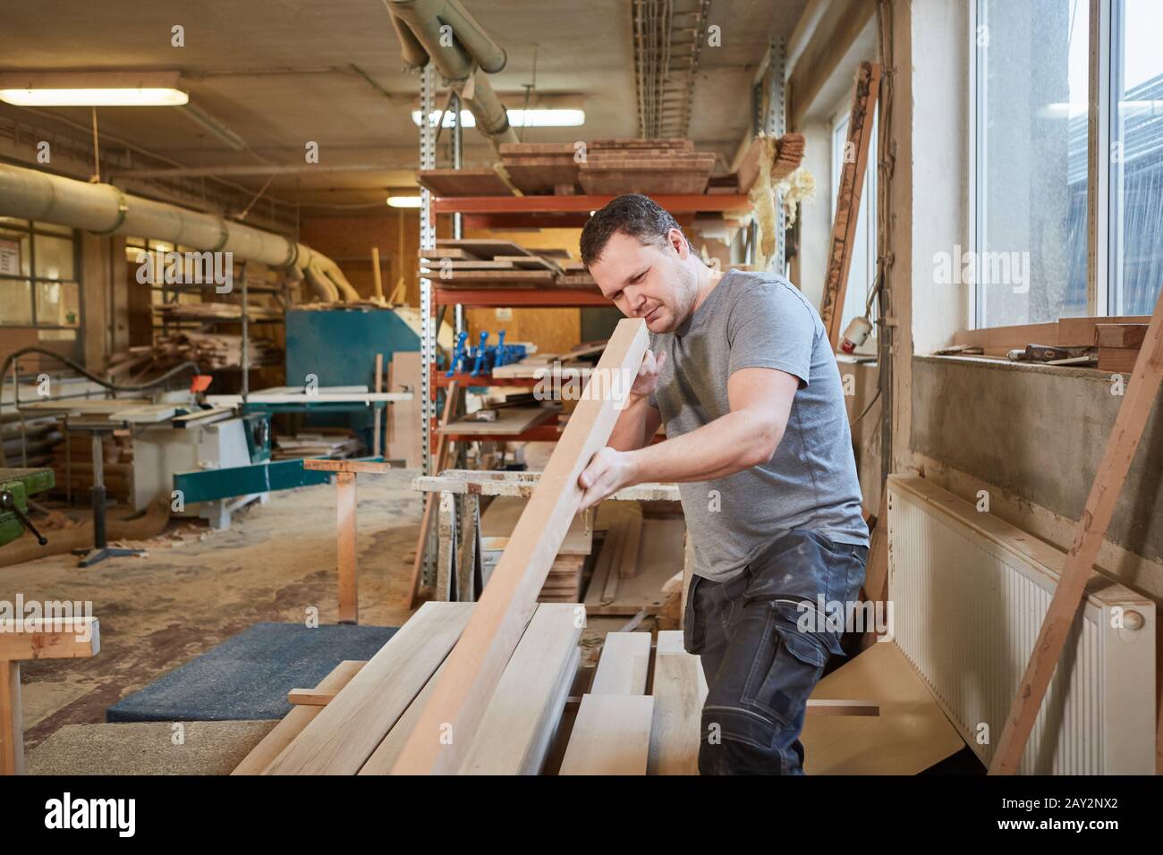 Carpenter checks a piece of lumber for quality in a carpenter's ...