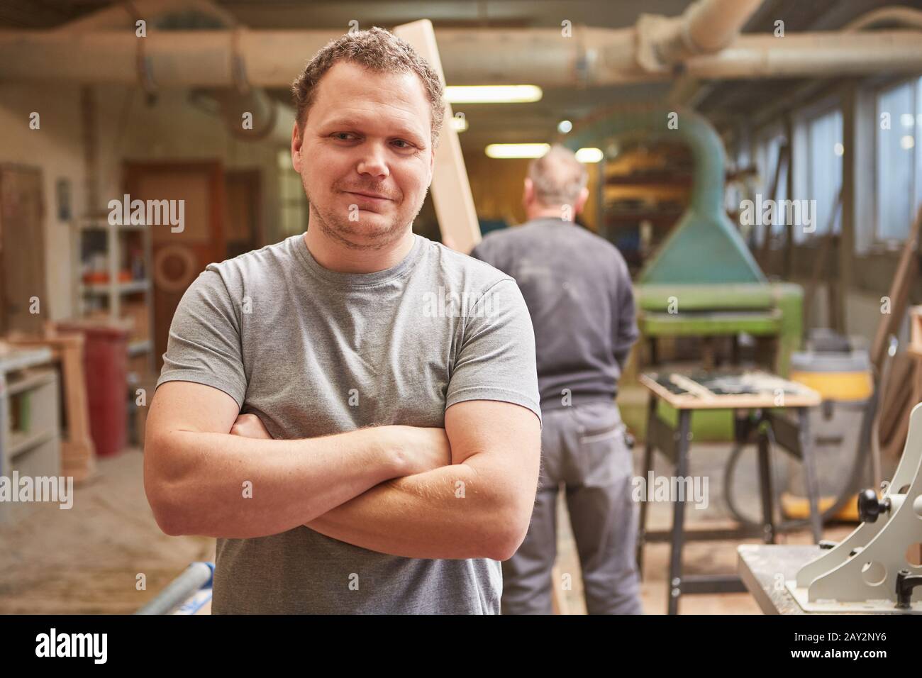 Carpenter in artisan training with arms crossed Stock Photo - Alamy