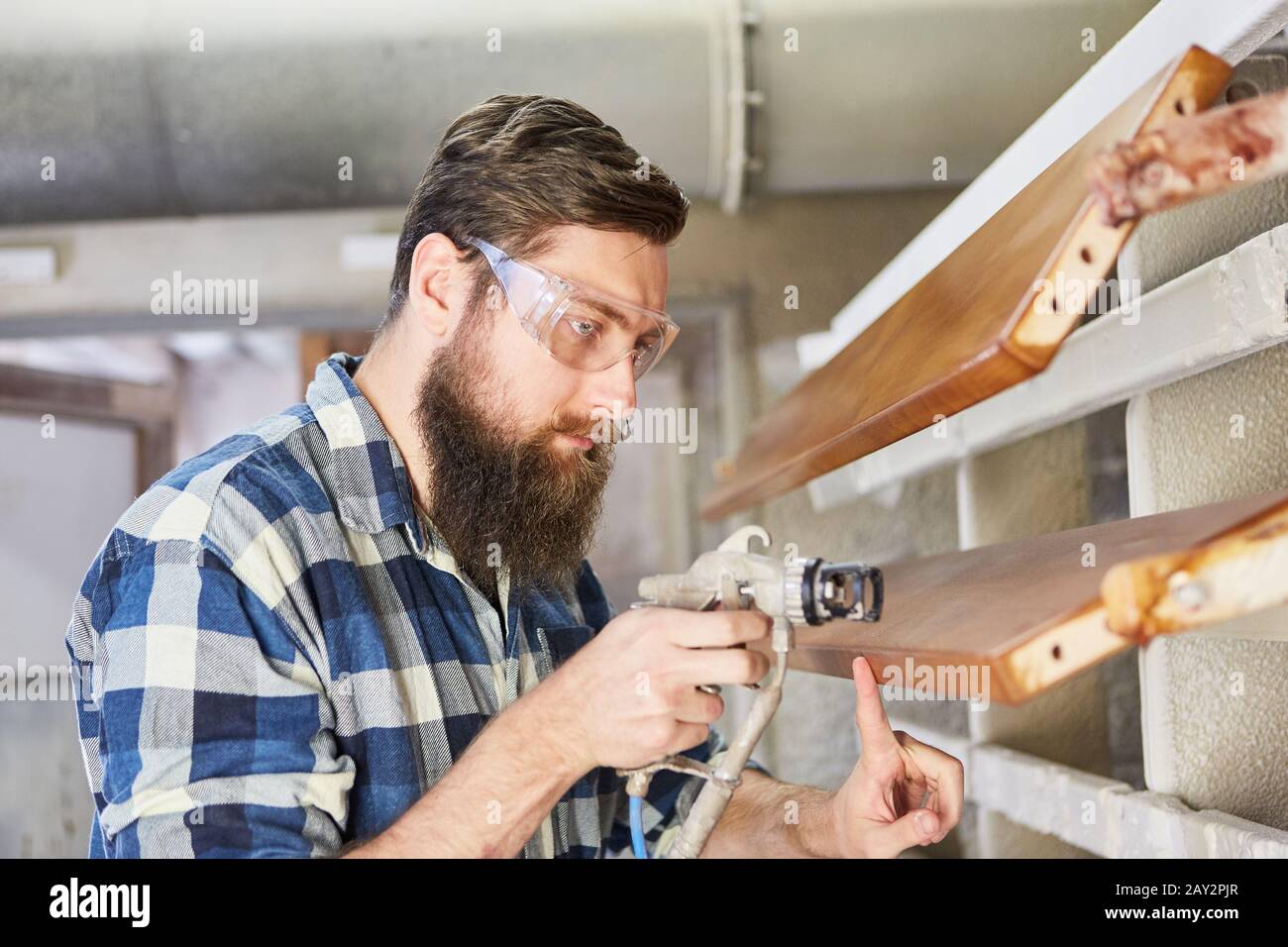 Carpenter as a painter when painting wood with spray paint Stock Photo ...