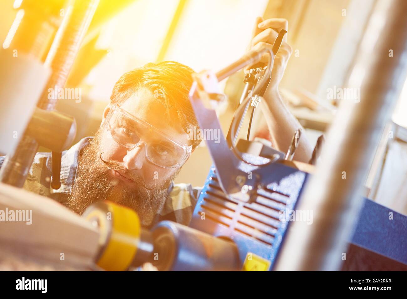Hipster carpenter uses drill with laser display of the drilling point ...