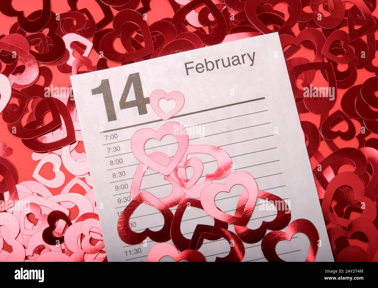 Calendar page open to February 14, Valentine's Day surrounded by shiny ...