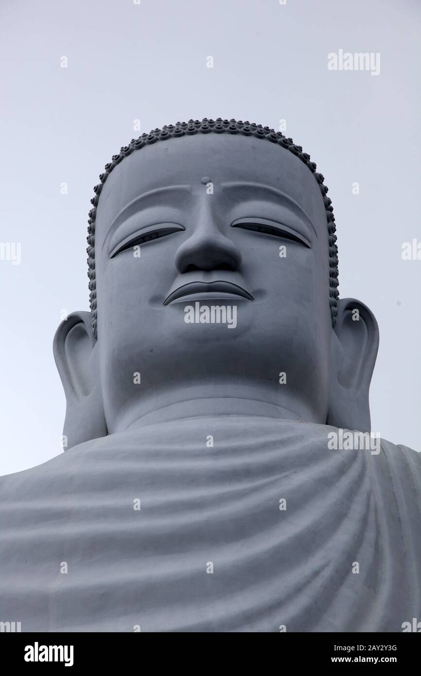 It's a photo of the head of a Buddha statue that is smiling with closed ...