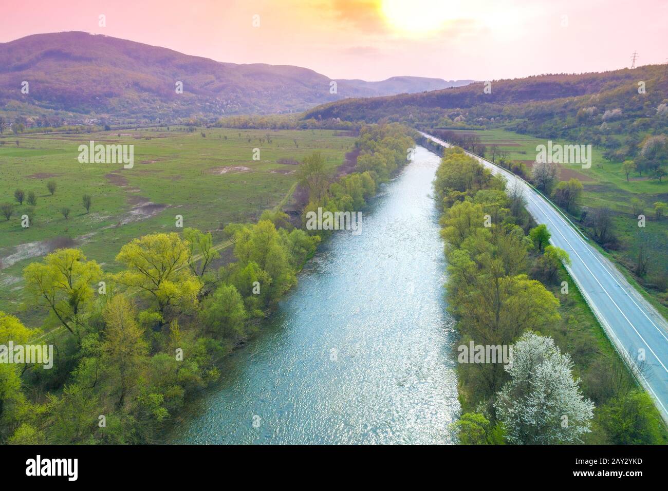 Panoramic view of a mountain valley with river and highway in early ...