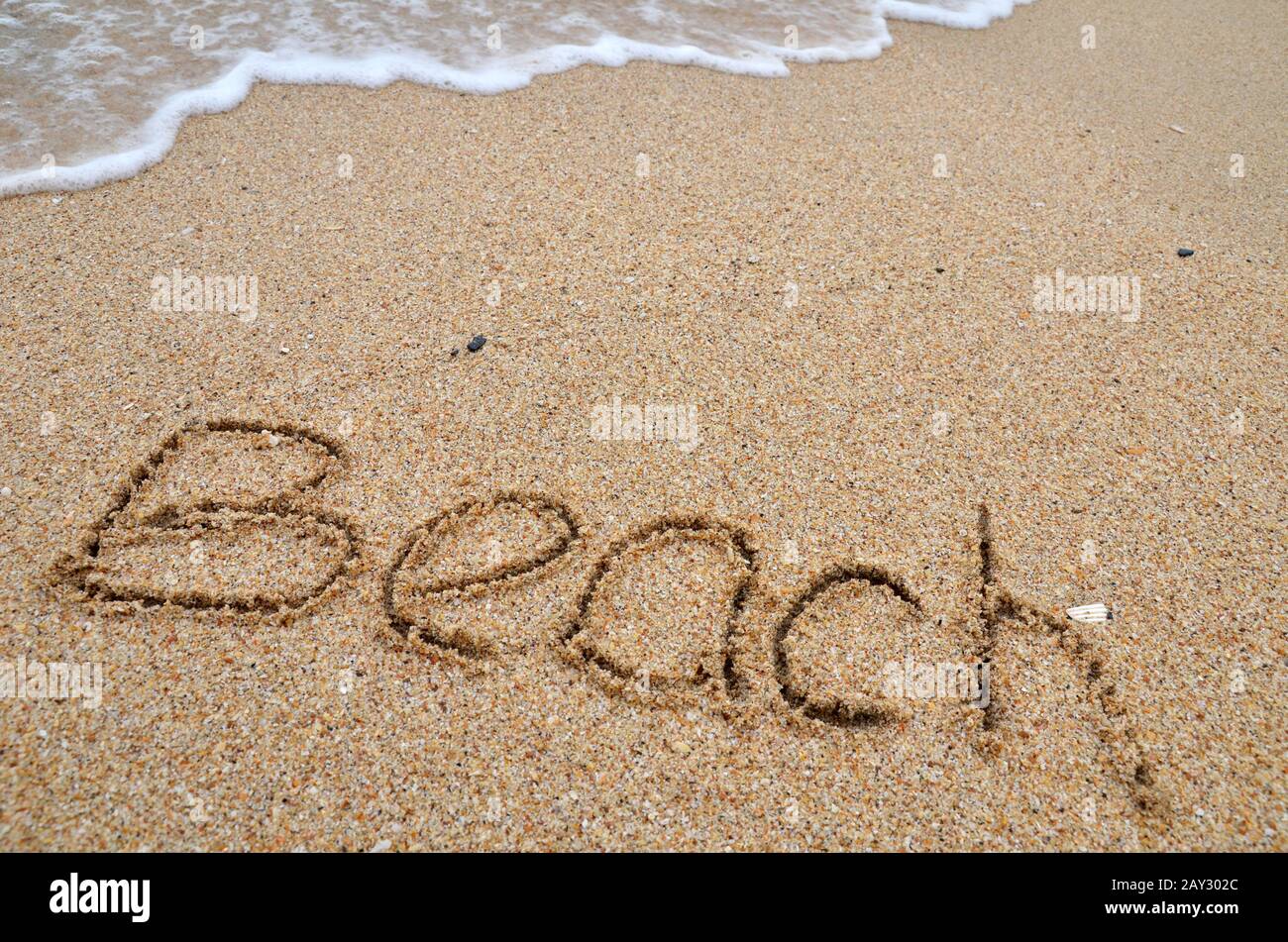 Beach word written on the sandy beach Stock Photo - Alamy