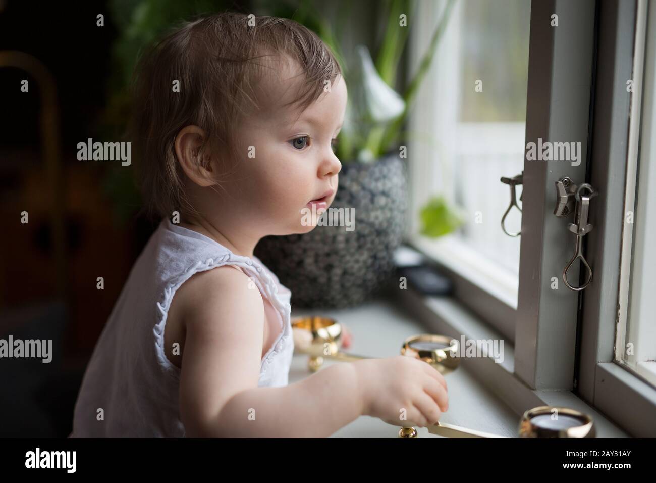 Girl looking through window Stock Photo - Alamy