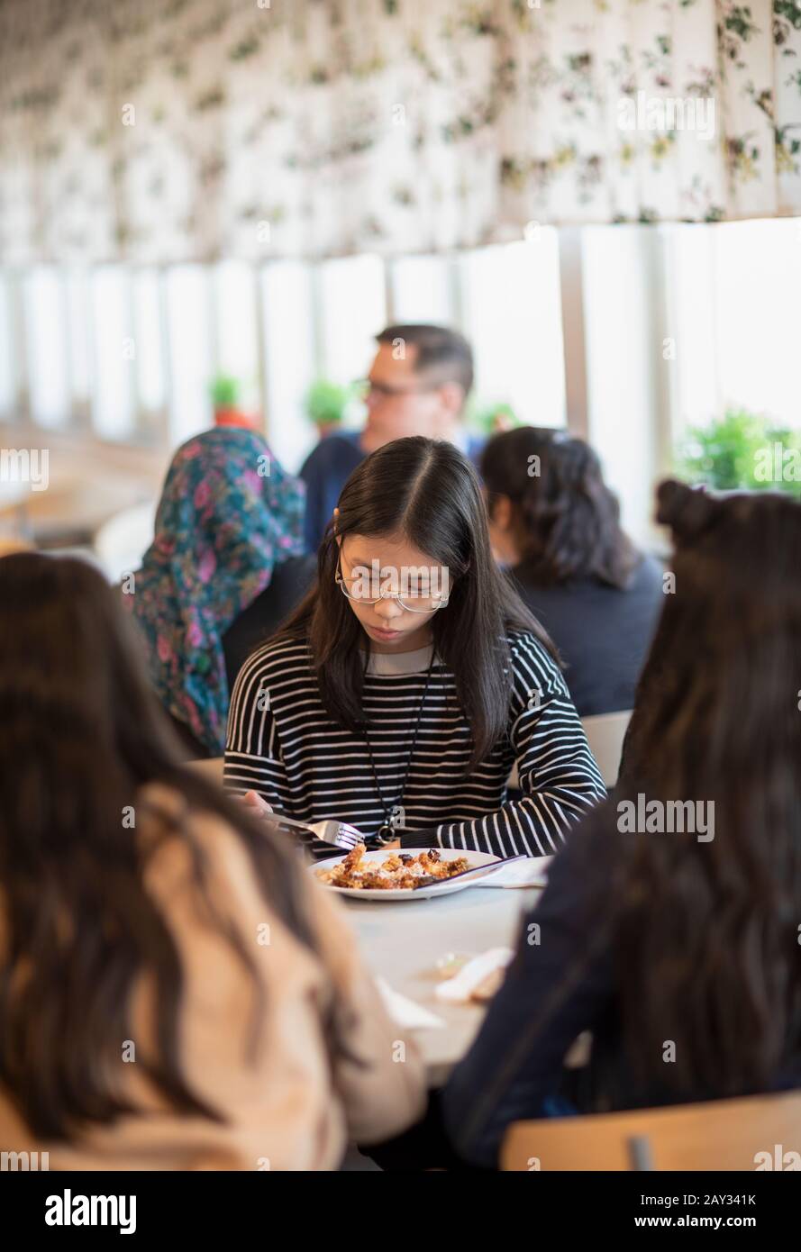 Girl eating lunch school canteen Stock Photo - Alamy