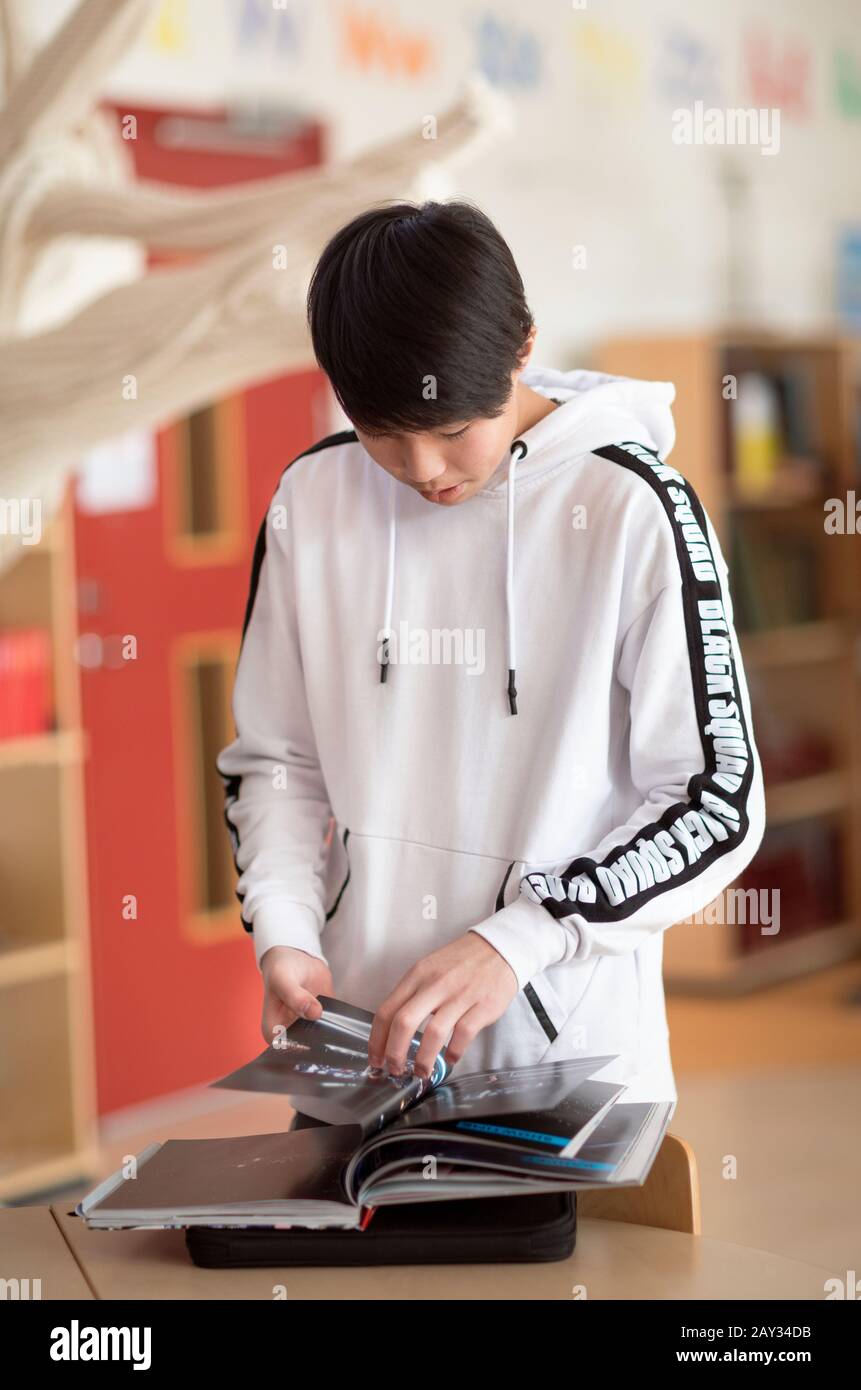 Teenage boy reading book Stock Photo - Alamy