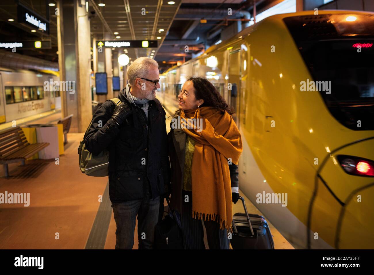 Couple on train station platform Stock Photo - Alamy