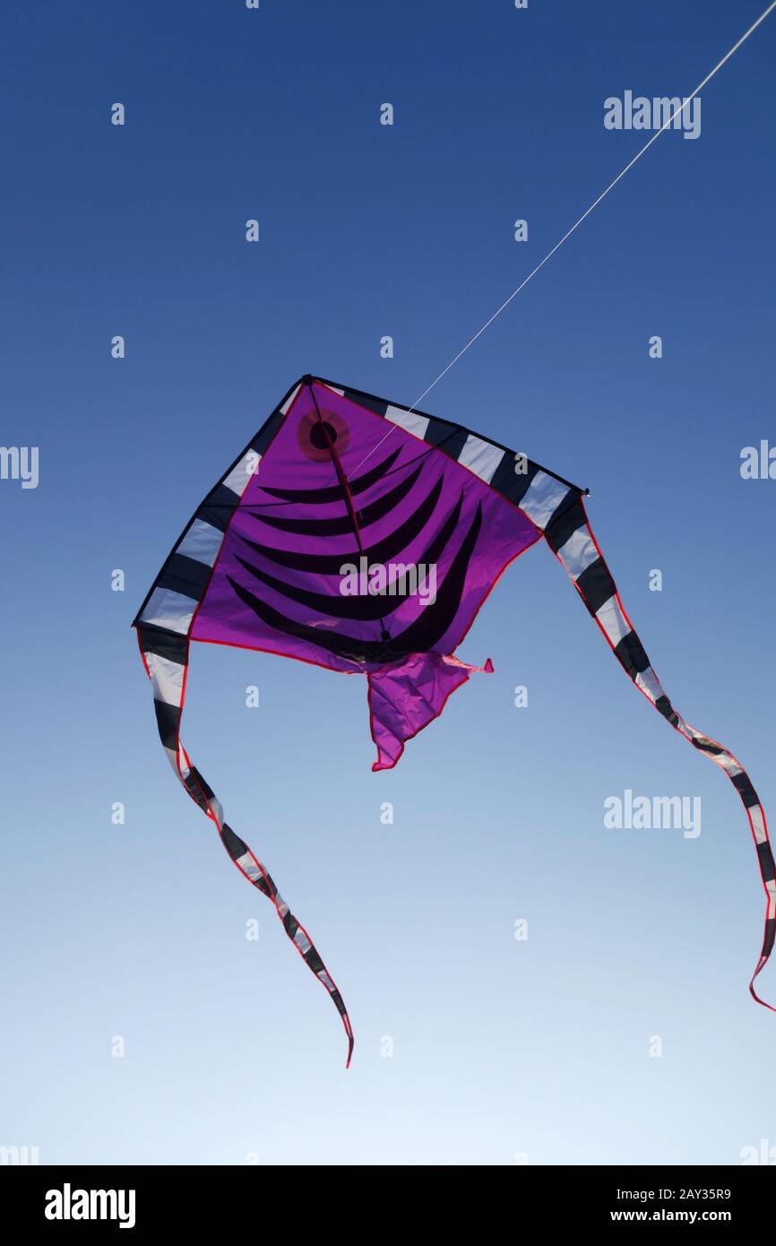 Colorful kite flying up in blue sky Stock Photo - Alamy