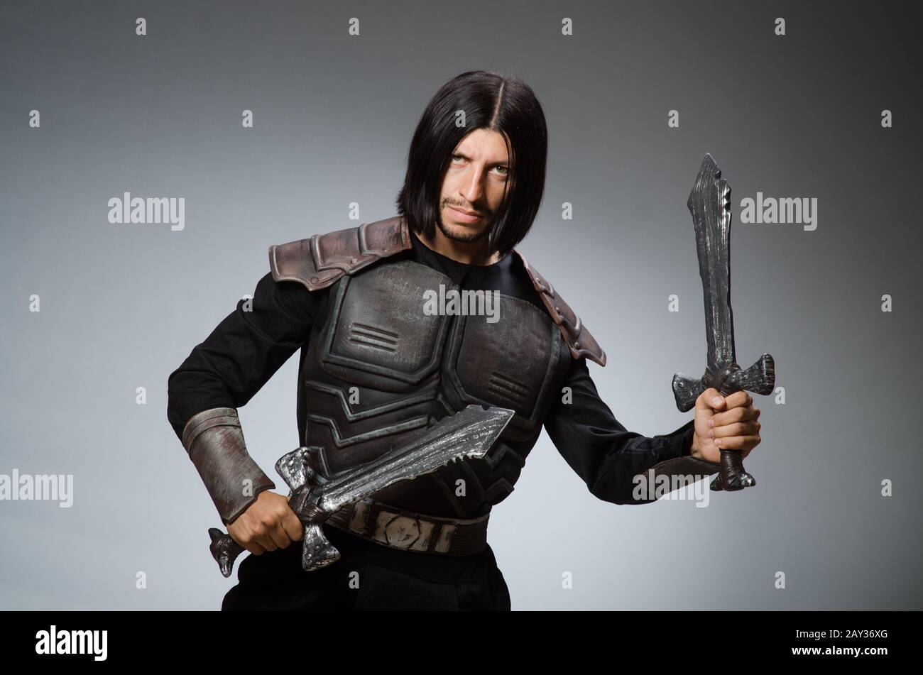 Angry knight with sword against dark background Stock Photo - Alamy