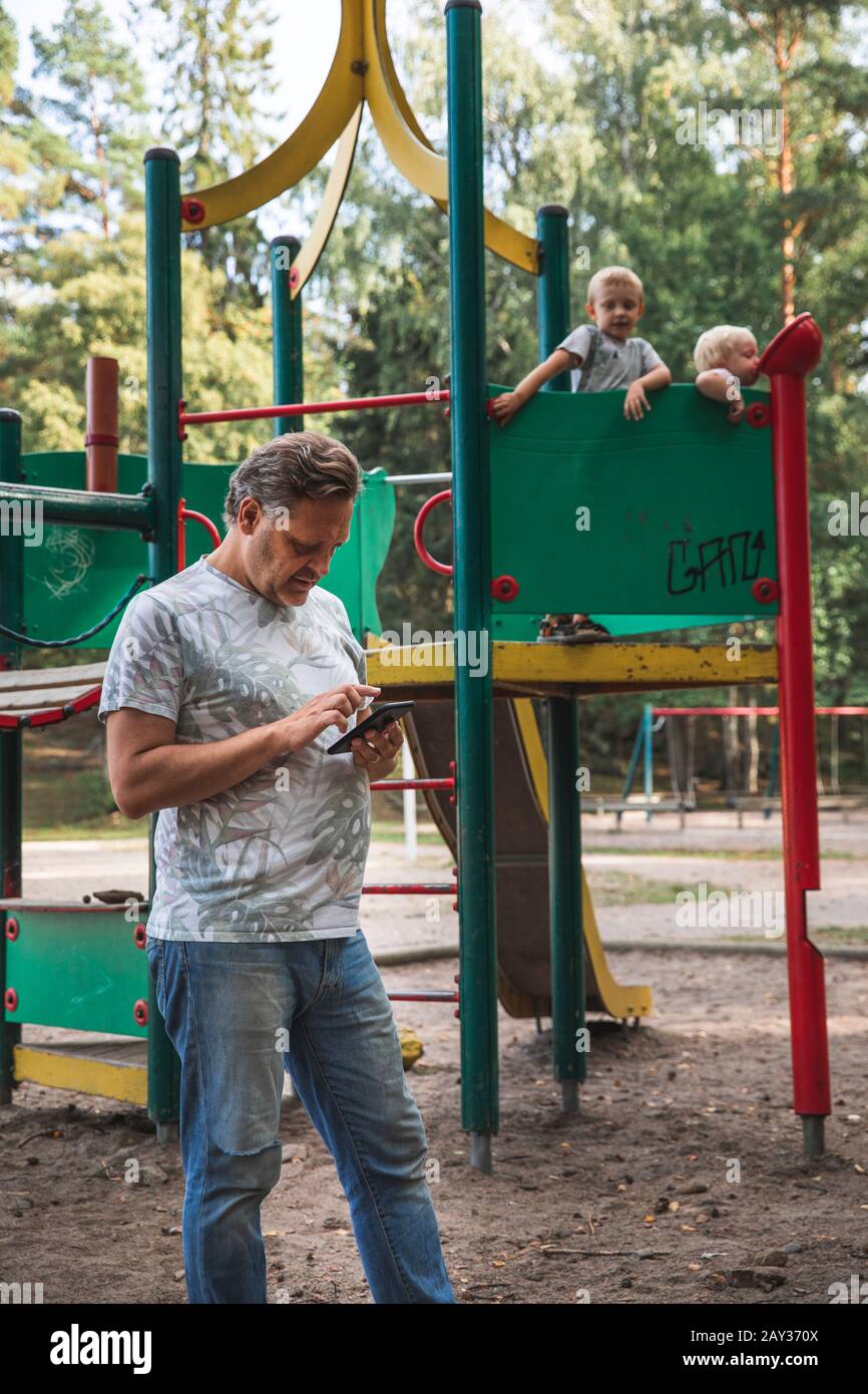 Father with kids on playground Stock Photo - Alamy