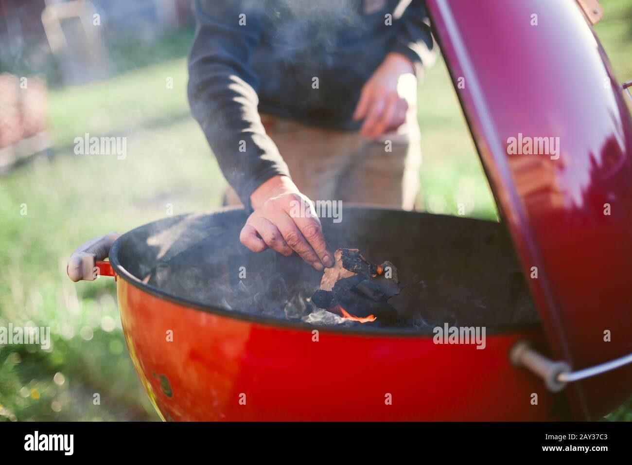 Hands lighting fire in barbecue Stock Photo - Alamy