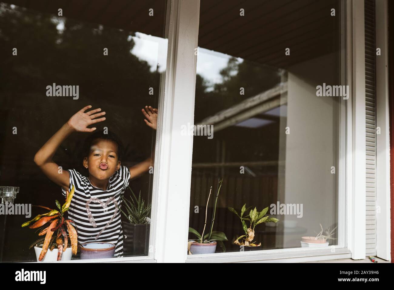 Girl looking through window Stock Photo - Alamy