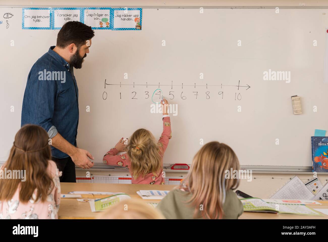 Girl at board in classroom Stock Photo - Alamy