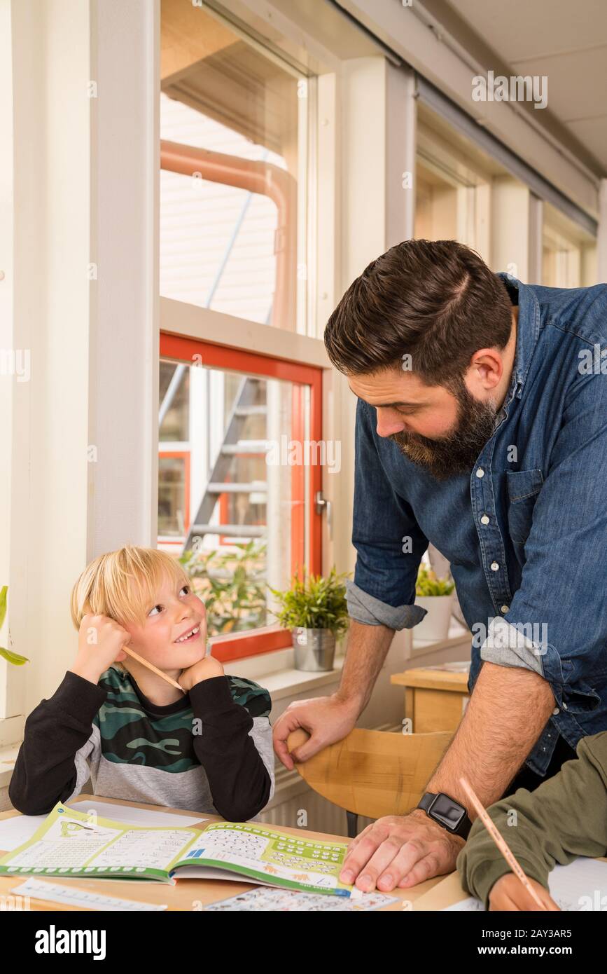 Teacher with boy in classroom Stock Photo - Alamy