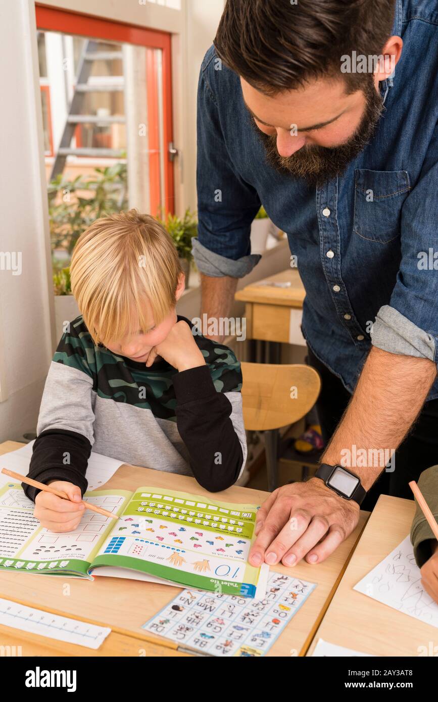 Teacher with boy in classroom Stock Photo - Alamy