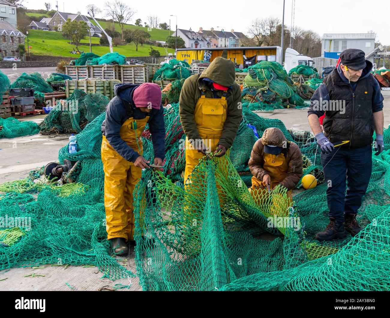 4 fishermen mending nets in union hall harbour ireland Stock Photo - Alamy