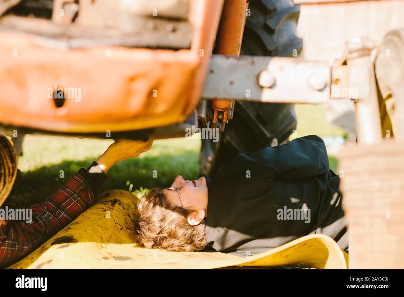 Woman checking tractor Stock Photo - Alamy