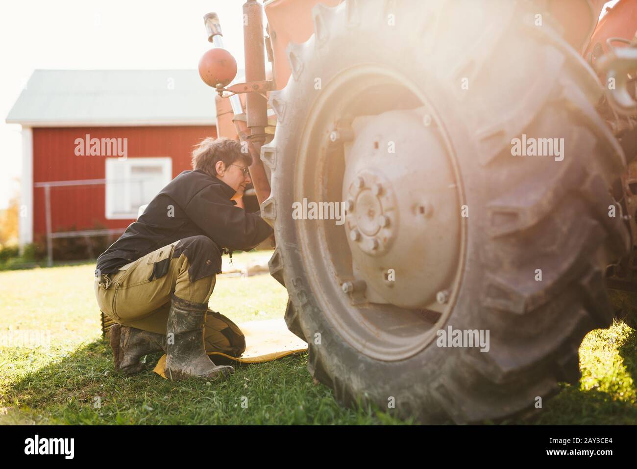 Woman repairing tractor Stock Photo - Alamy
