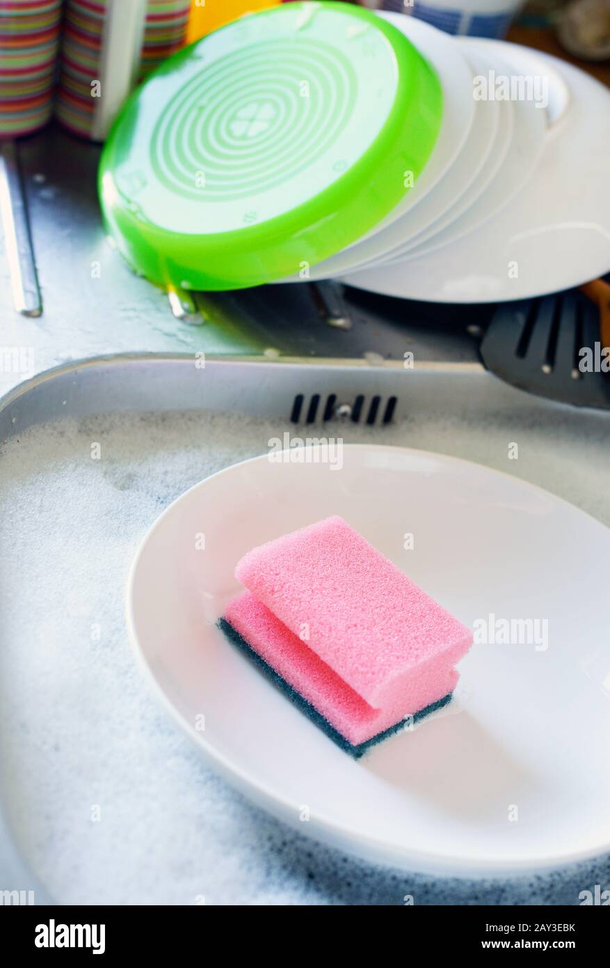 Kitchen with a sink and dishes and a colorful purple sponge Stock Photo ...