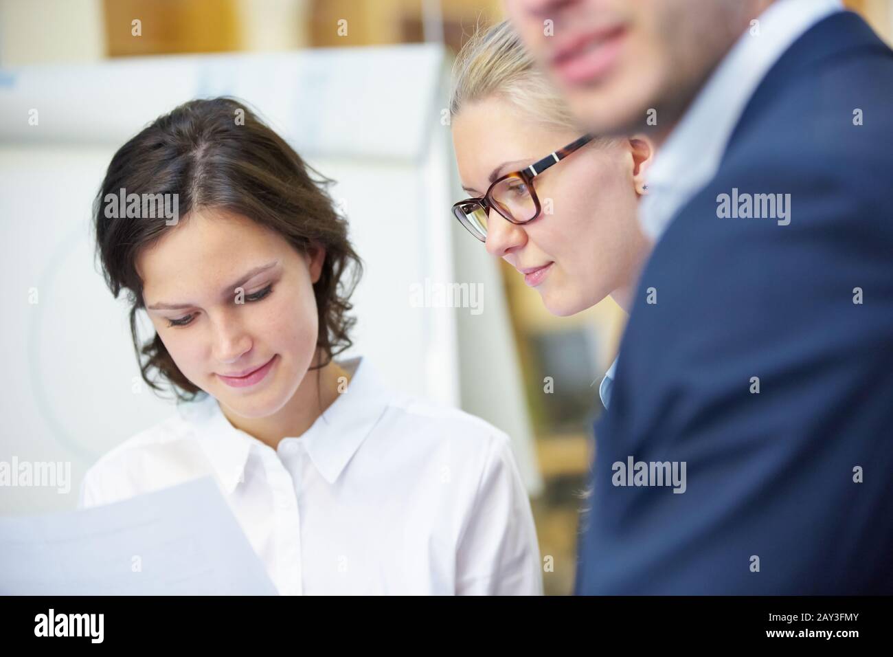 Three business people are in the office as a business team Stock Photo ...
