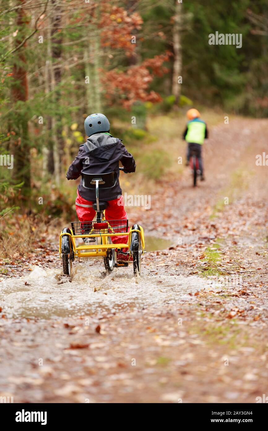 Child cycling through puddle Stock Photo - Alamy