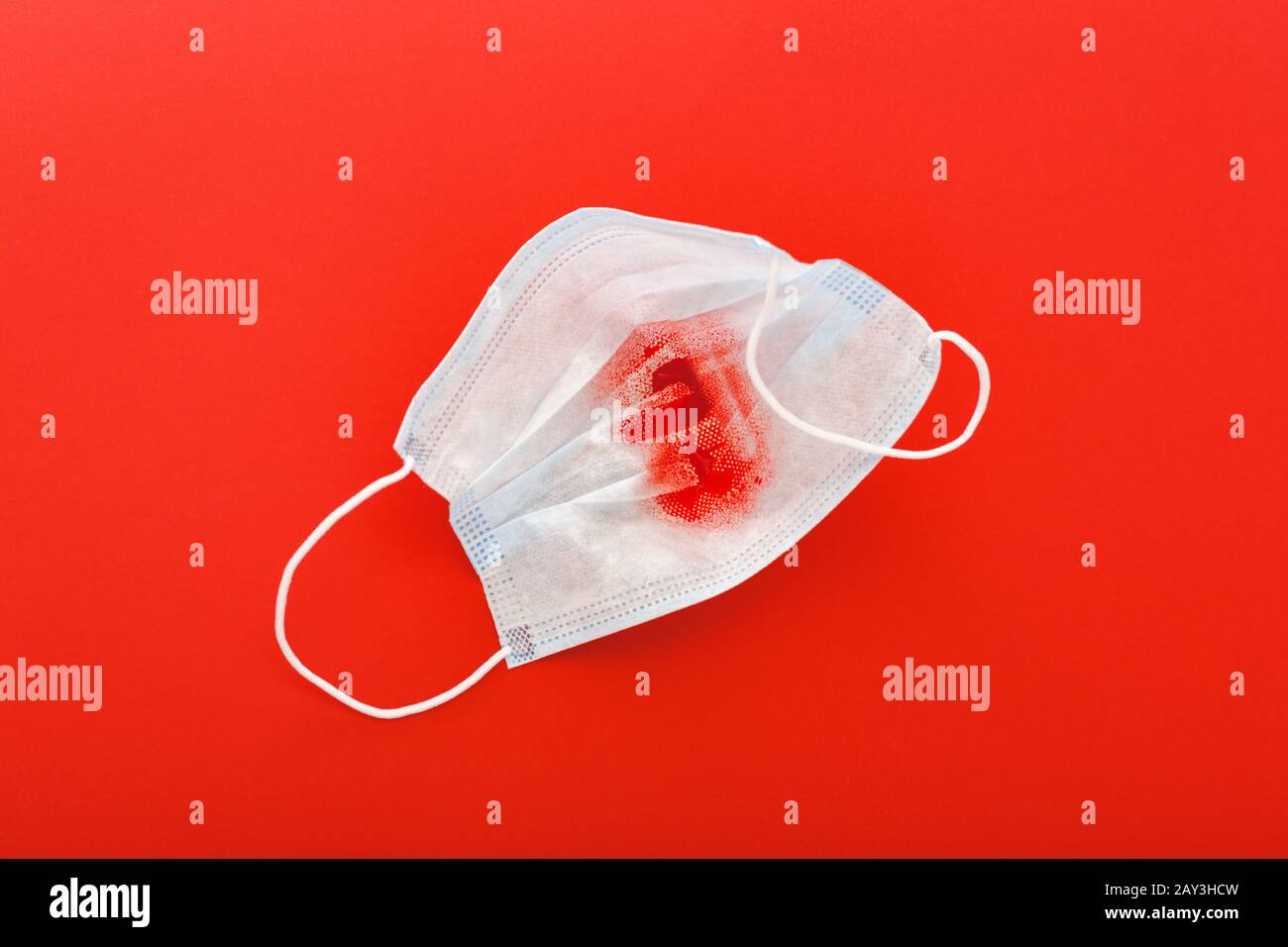 Hemoptysis, coronavirus, protective surgical mask with blood on red ...