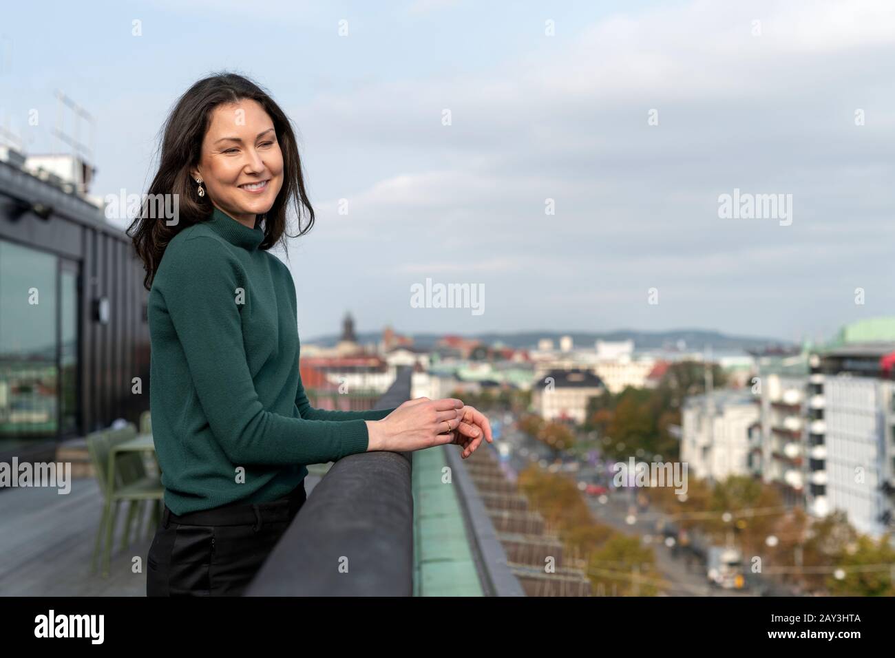 Woman on balcony looking at camera Stock Photo - Alamy