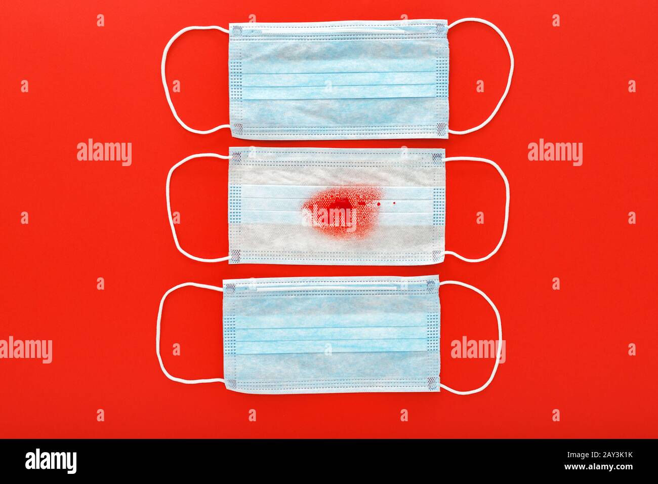 Hemoptysis, coronavirus, protective surgical mask with blood on red ...