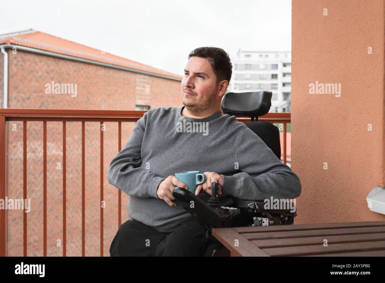 Man sitting on balcony Stock Photo - Alamy
