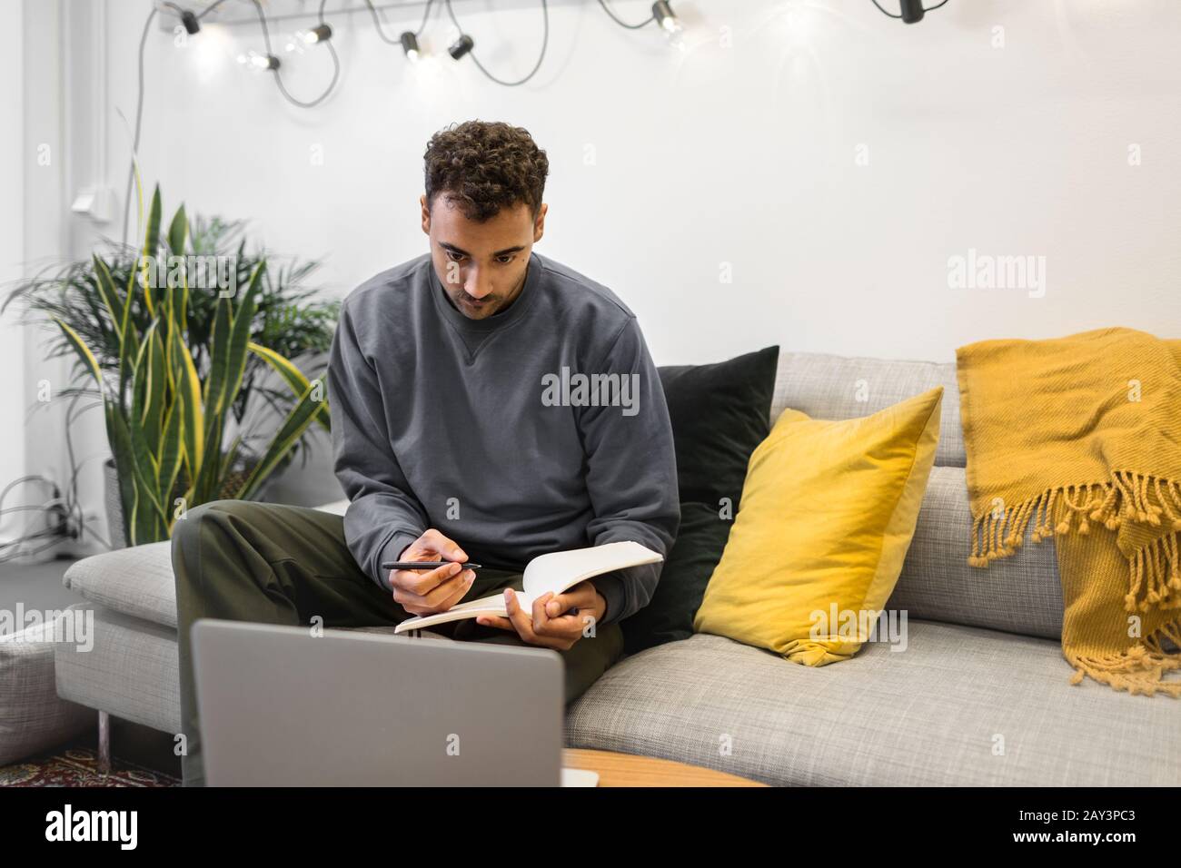 Man sitting on sofa Stock Photo - Alamy