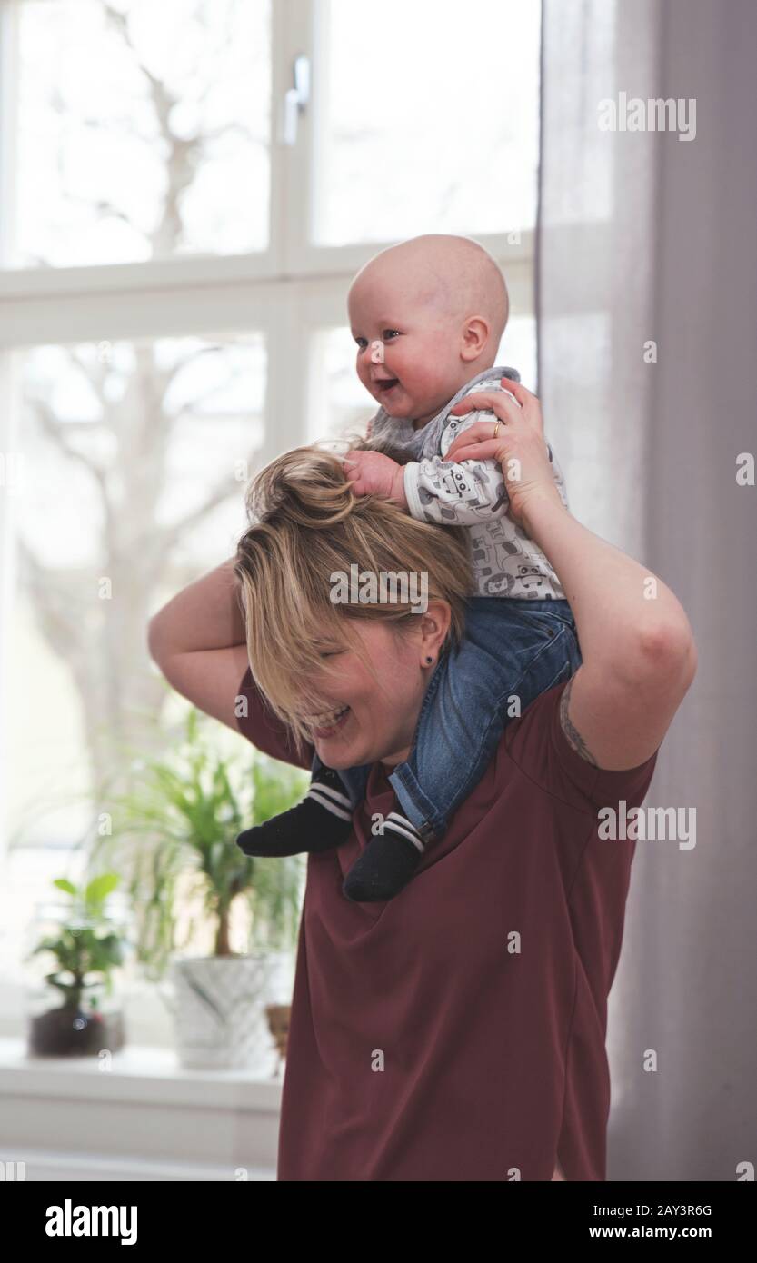 Mother carrying baby on shoulders Stock Photo - Alamy