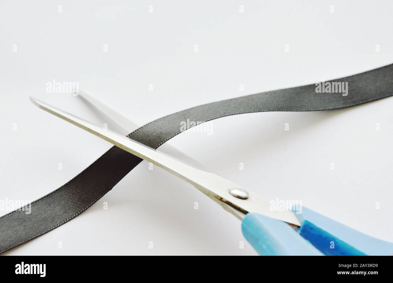scissors blade cutting black cloth ribbon on white background Stock ...