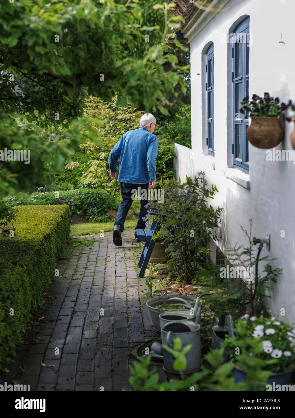 Old man watering plants hi-res stock photography and images - Alamy