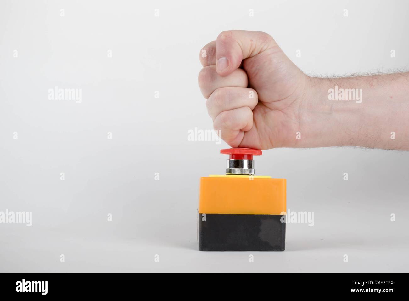 An industrial emergency stop button with a fist pressing down Stock ...