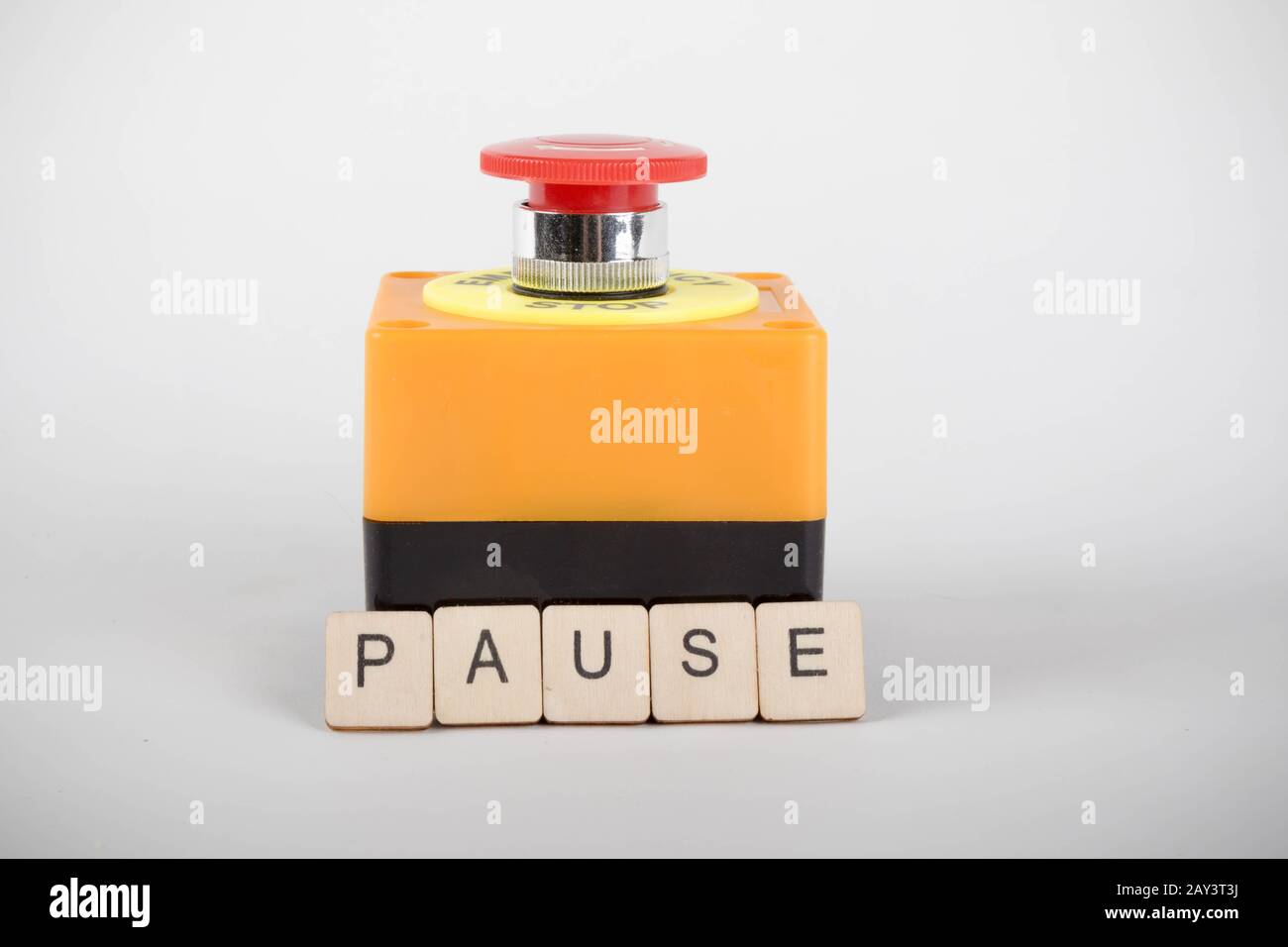 An industrial emergency stop button with a sign reading Pause Stock ...