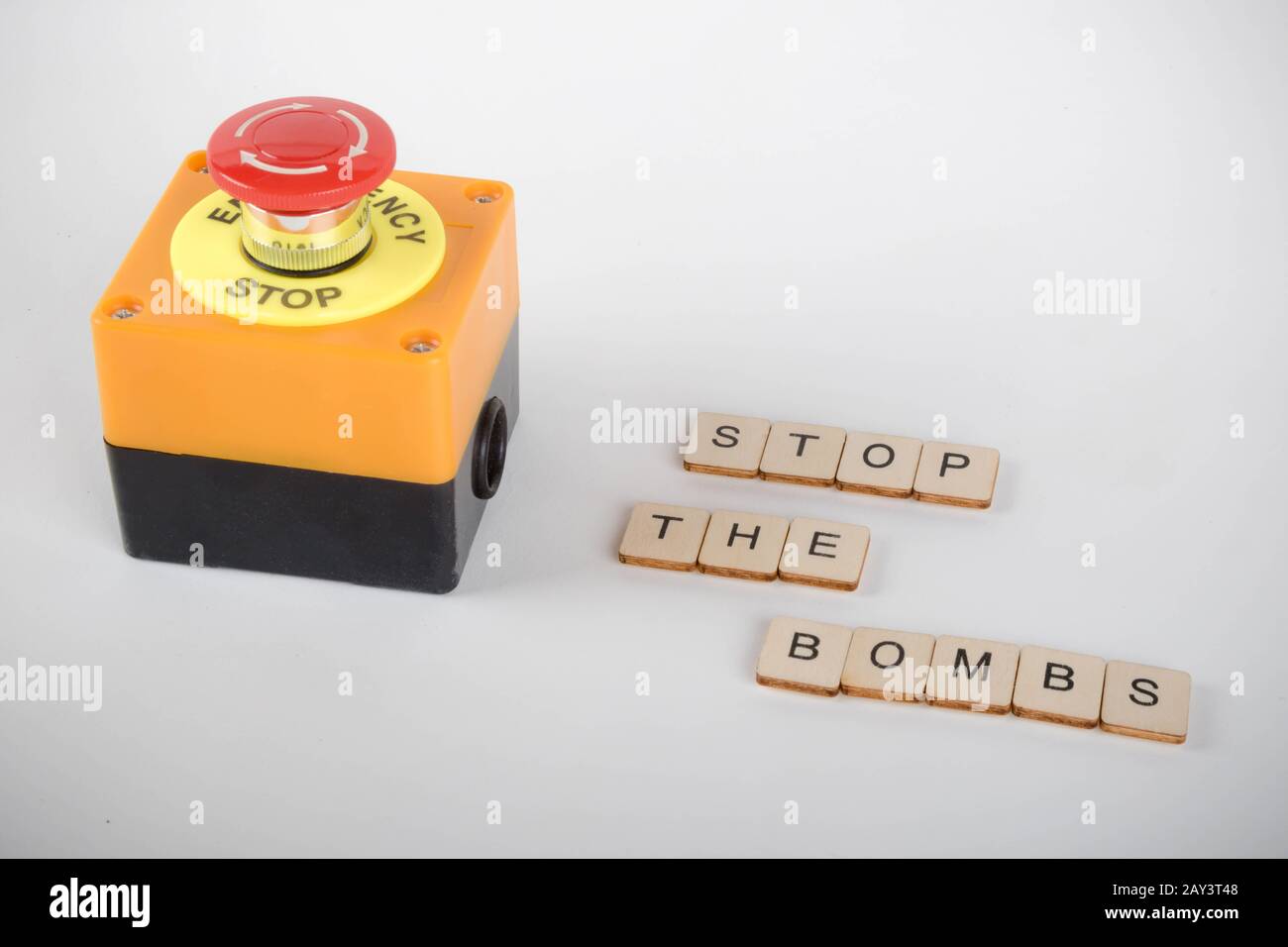 An industrial emergency stop button with a sign reading Stop The Bombs ...