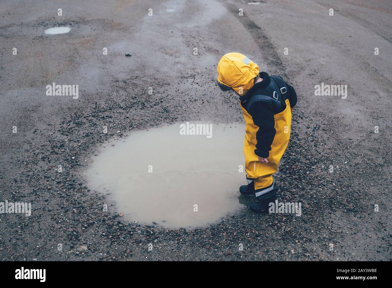 Child standing at puddle Stock Photo - Alamy
