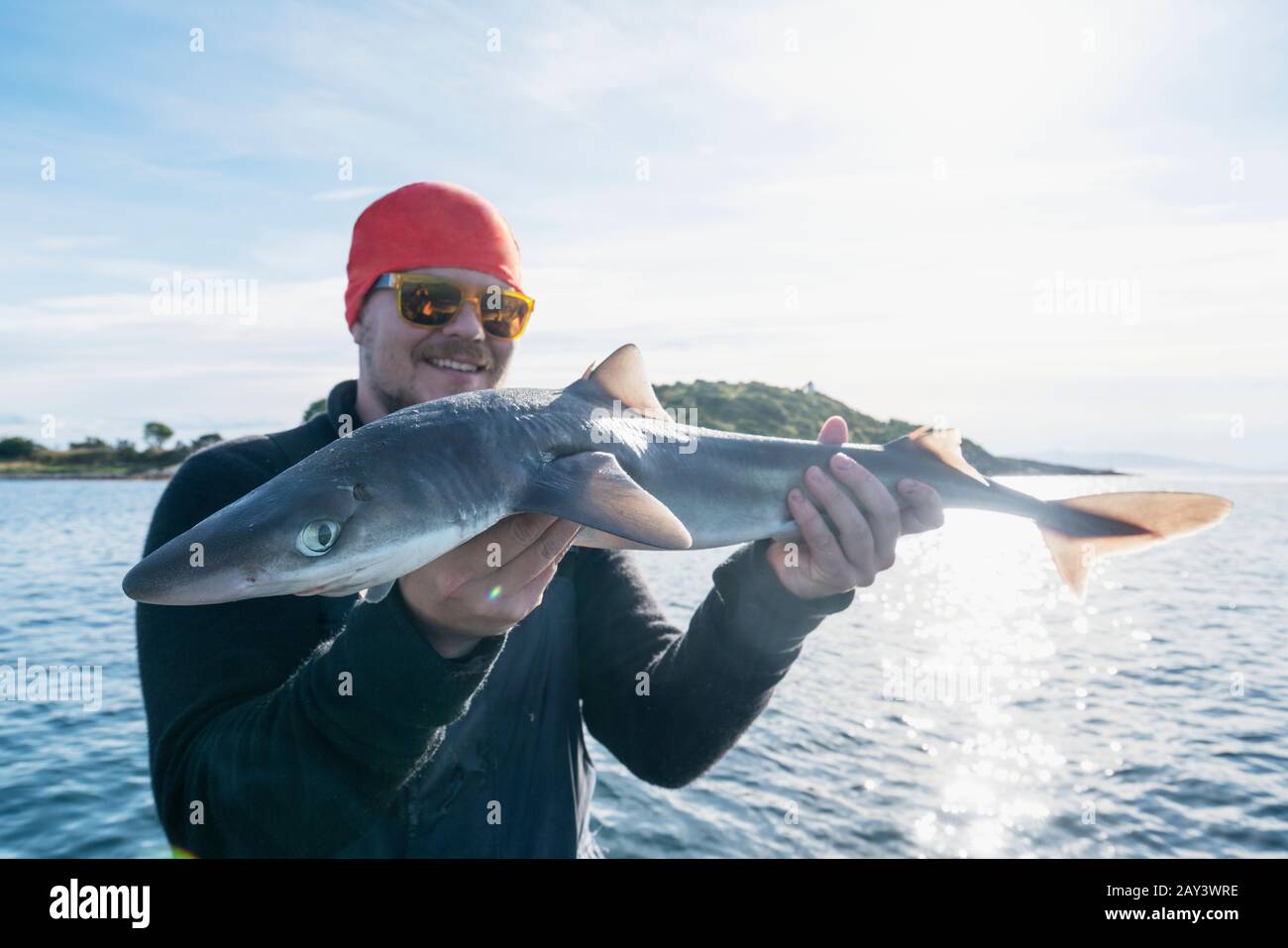 Man on boat holding fish Stock Photo - Alamy