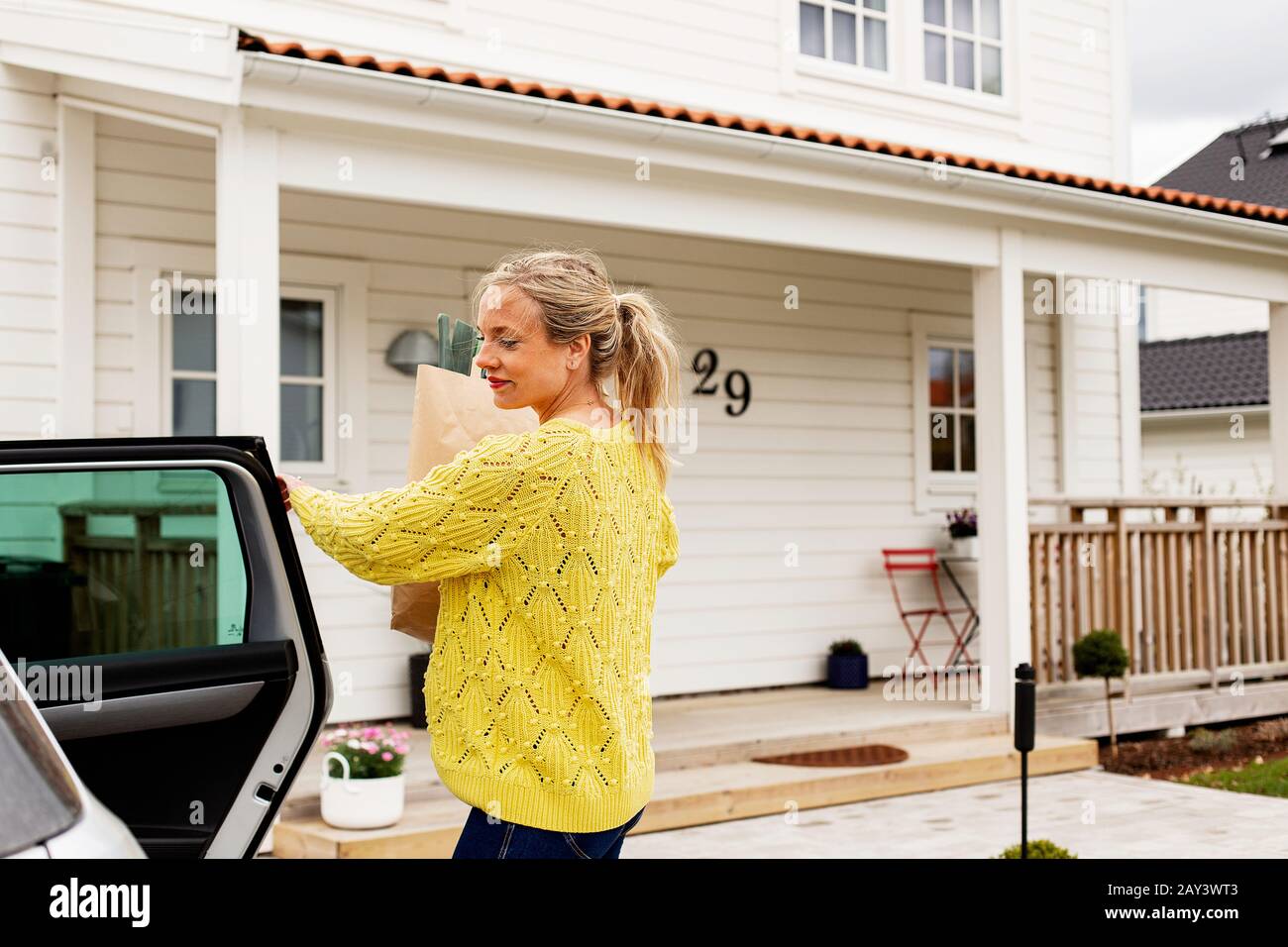 Woman in front of house Stock Photo - Alamy
