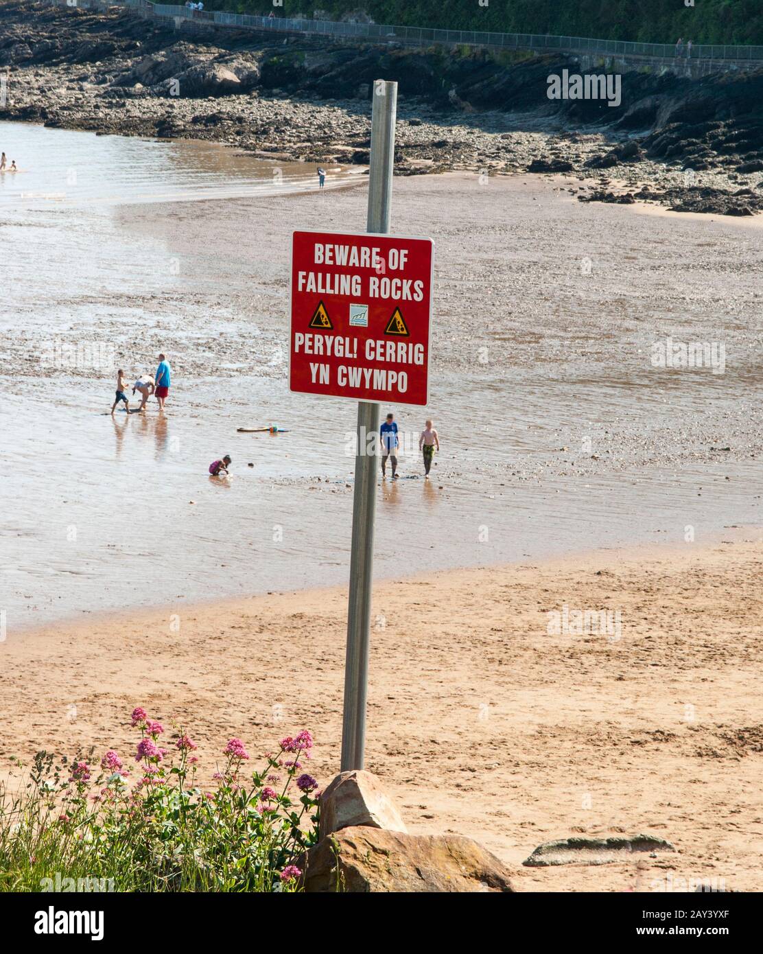 Warning sign post on a summer beach Stock Photo - Alamy