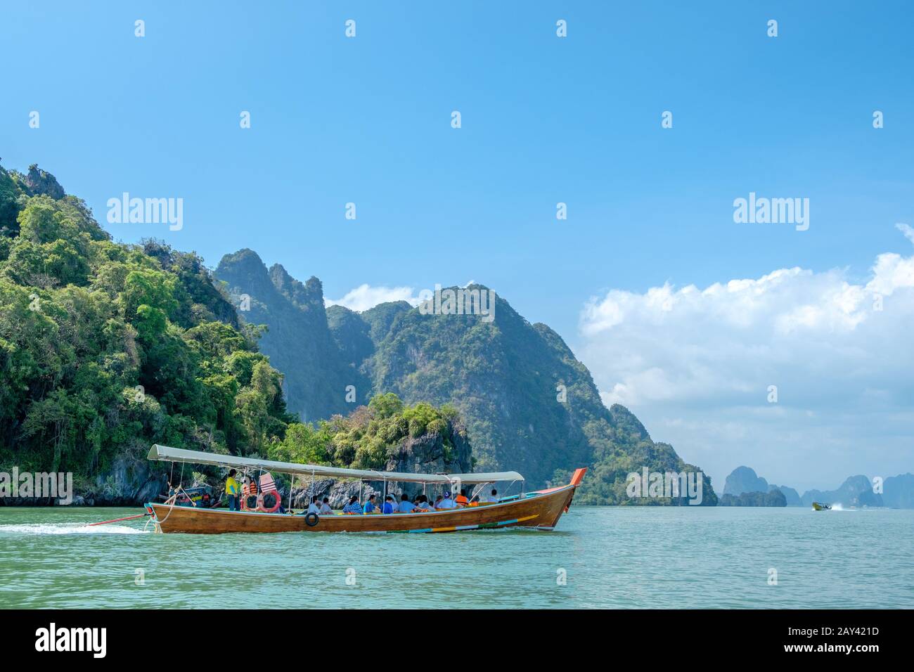 Tour boat among the scenic limestone islands in Phang Nga Bay. This is ...