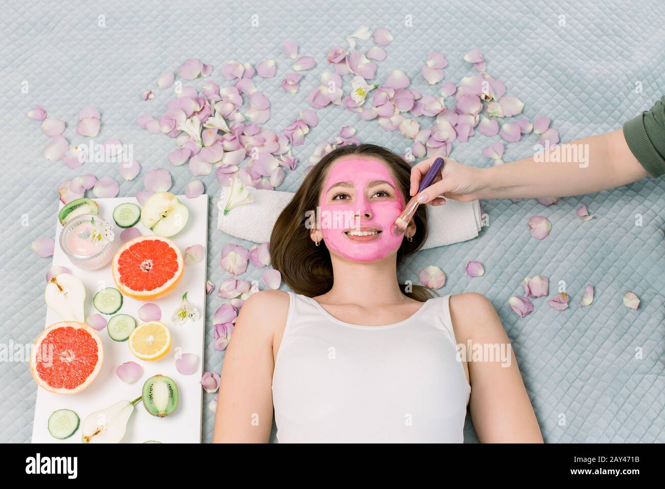 Spa therapy for young smiling woman receiving facial mask at beauty ...