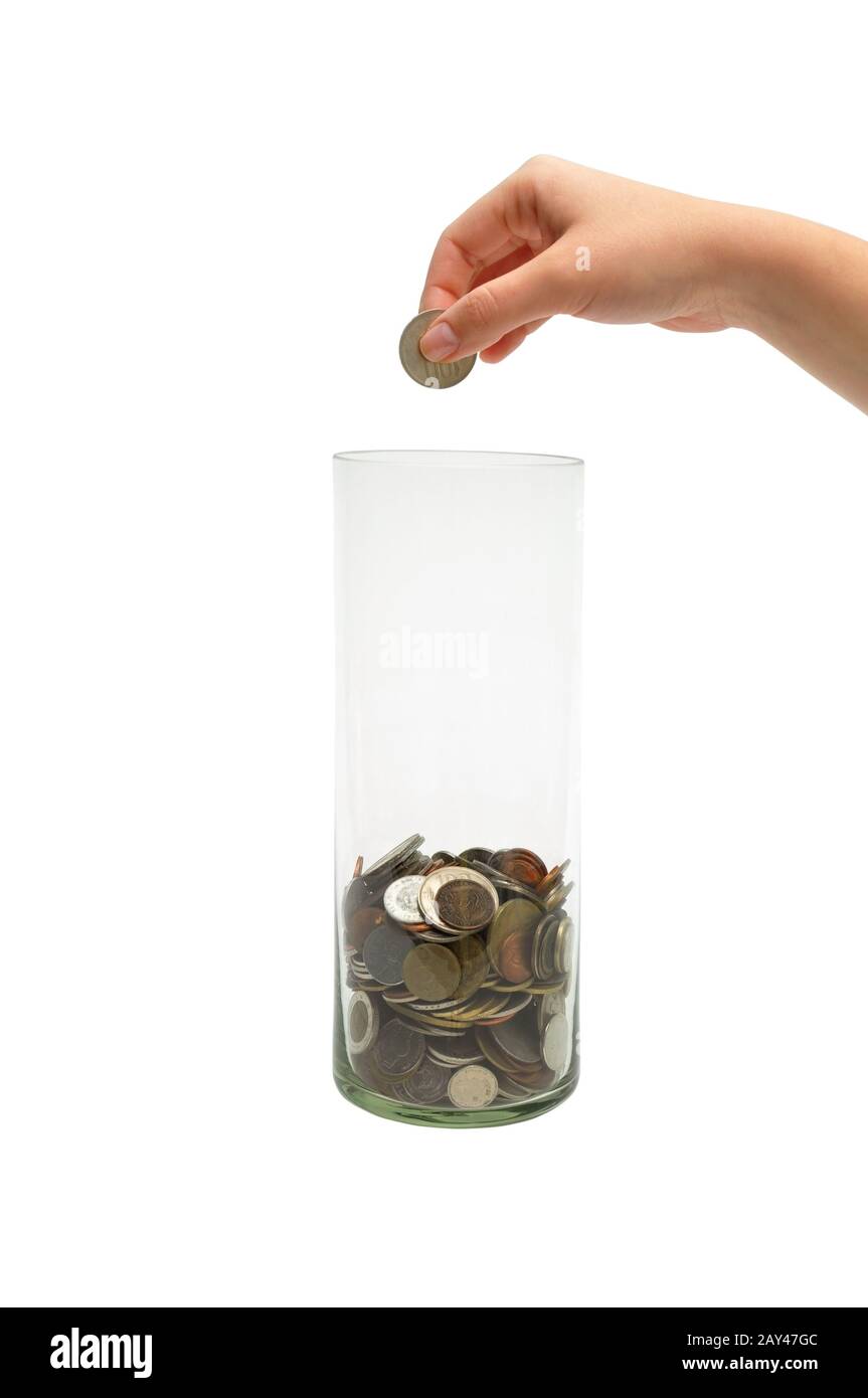 dropping coin into glass jar Stock Photo - Alamy