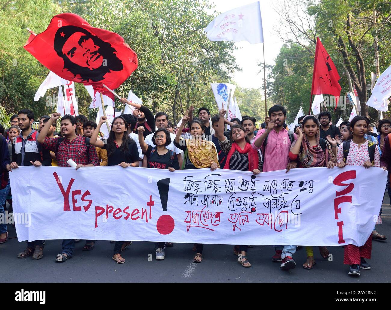 Jawaharlal Nehru University students march while holding a banner and ...