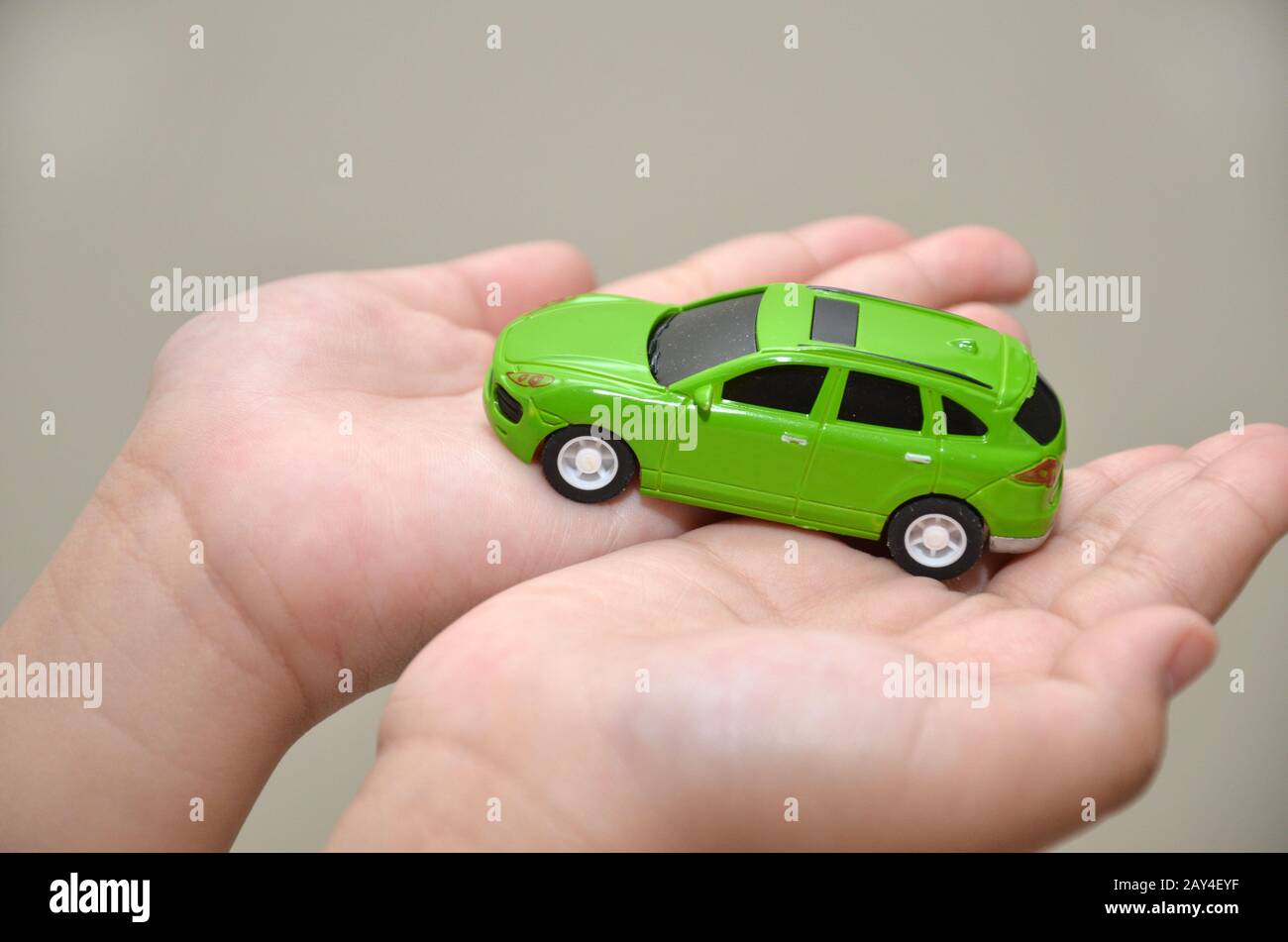 Green toy car on hand Stock Photo - Alamy
